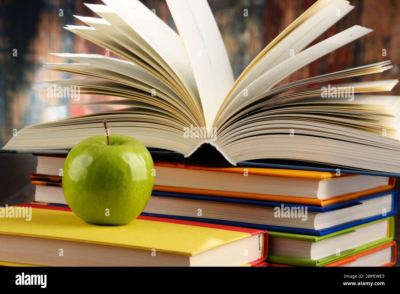 Composition with hardcover books and apple Stock Photo - Alamy