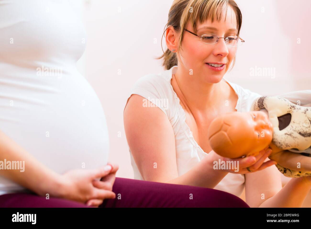 Midwife giving pregnant woman antenatal care for childbirth in practice ...