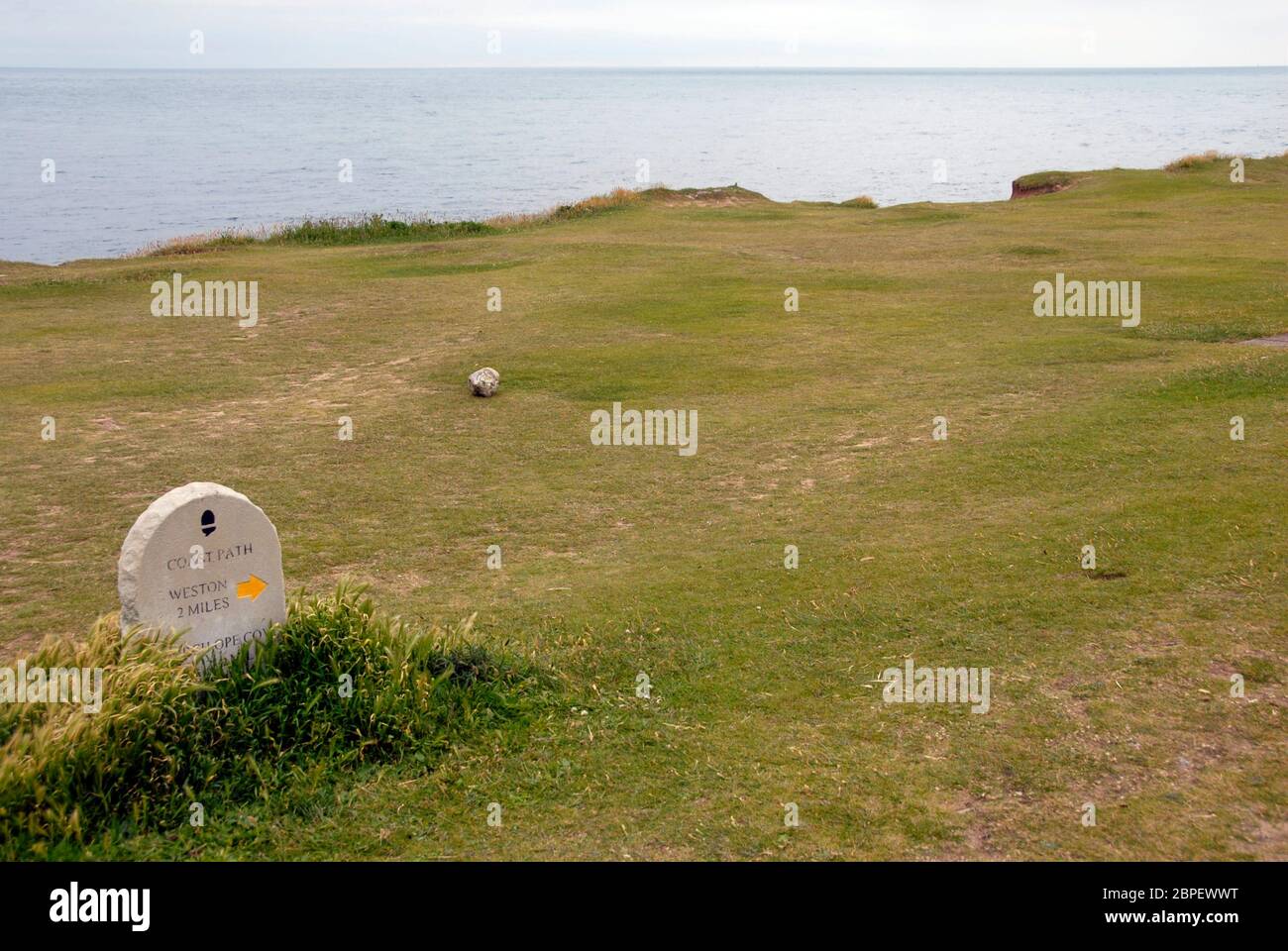 Marker on cliff top showing the coastal path and distance to Weston as ...