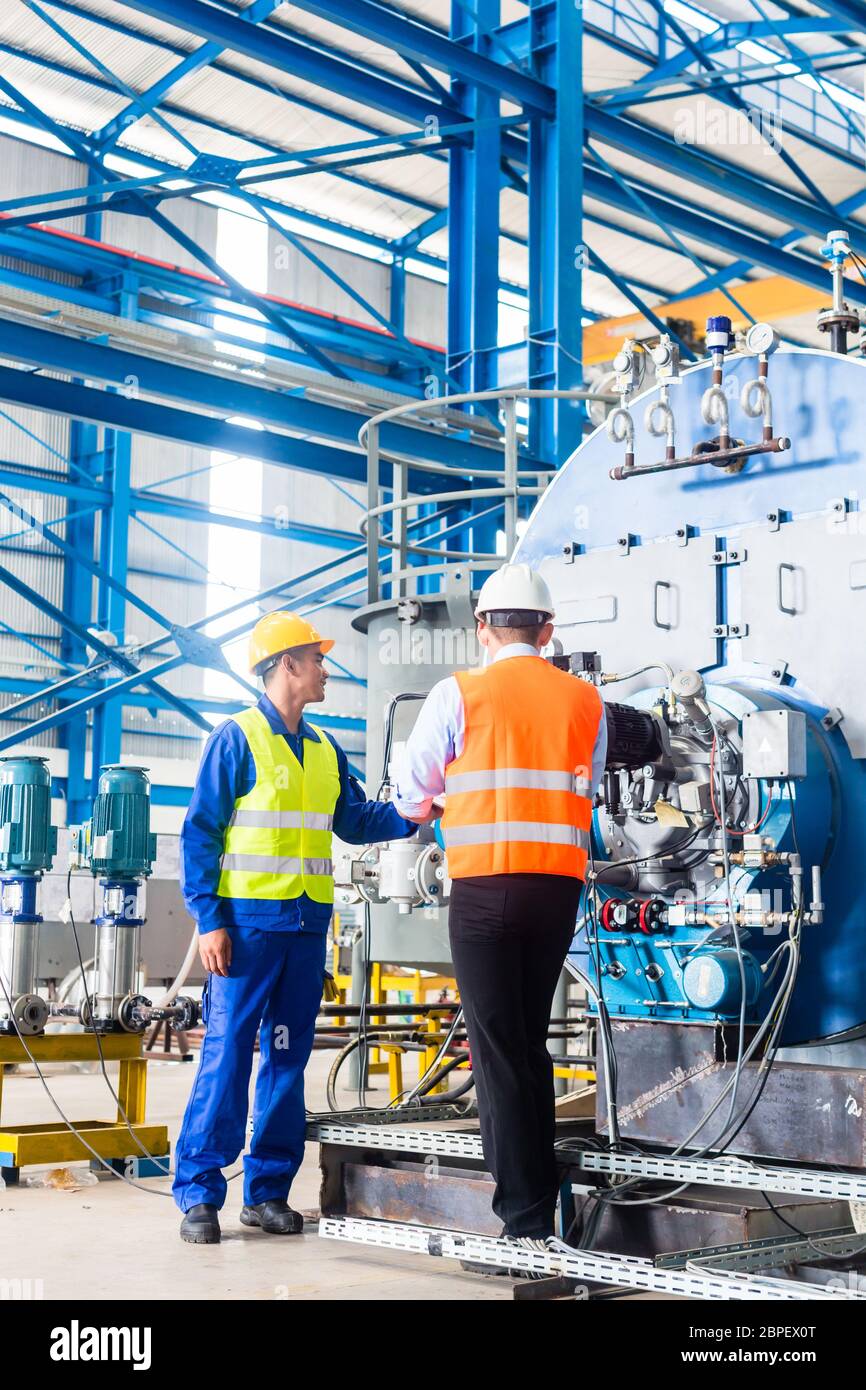 Worker and manager in industrial factory discussing acceptance of ...