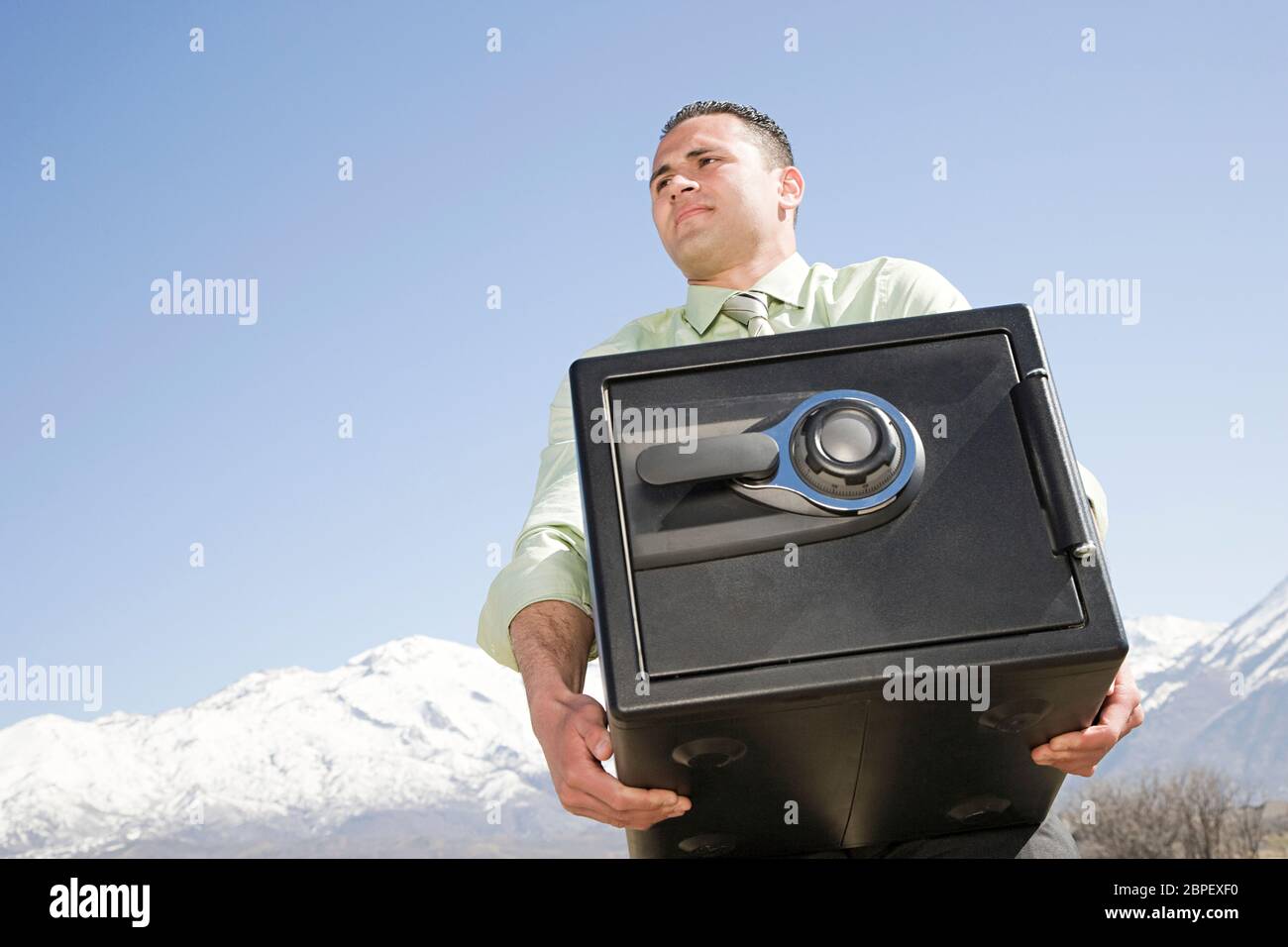 Man carrying safe near mountains Stock Photo - Alamy