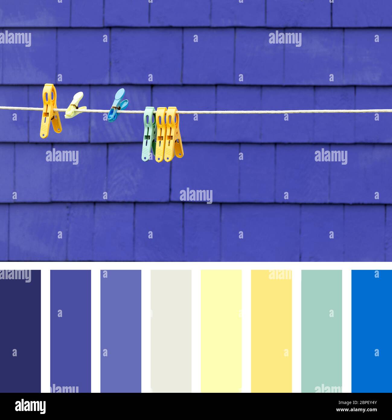 Washing line with colourful clothes pegs, against a purple wood shingle ...