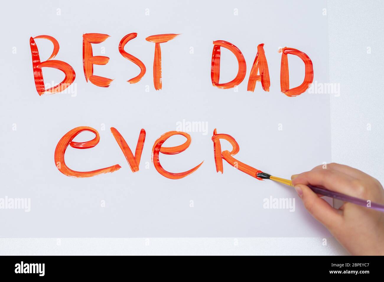 Top view of hand of child drawing handwritten text Best Dad Ever on ...