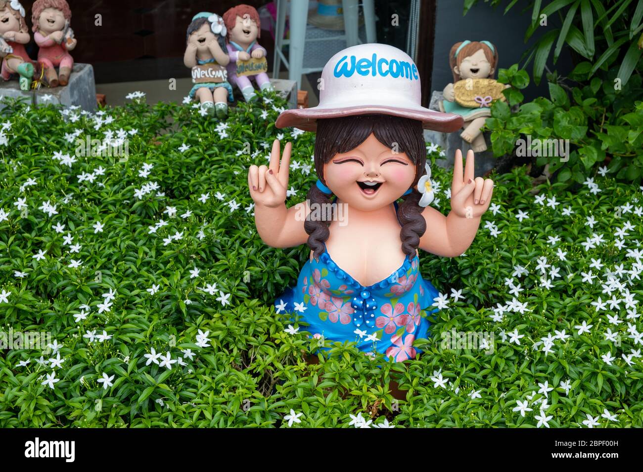 asian welcome doll in flowers Stock Photo - Alamy