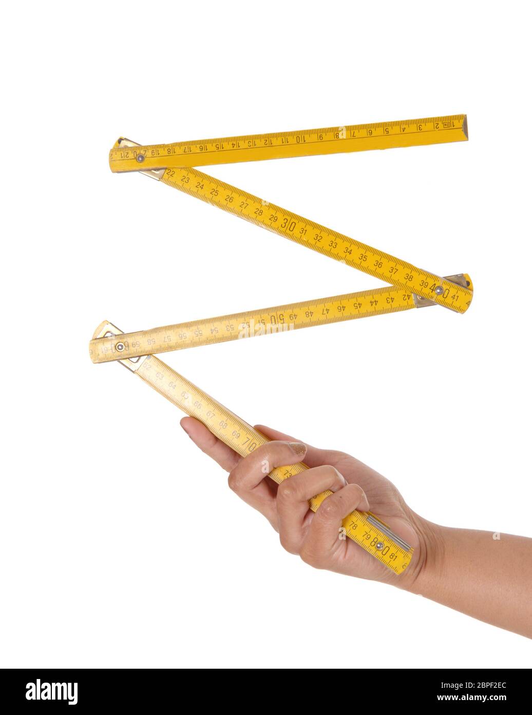 A close up image of a hand holding a European yellow wood ruler a ...