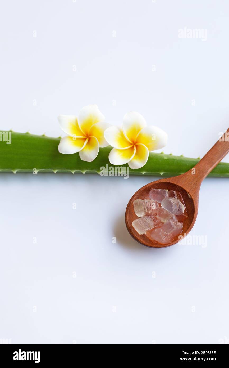 Aloe vera gel in wooden spoon and aloe vera leave with flower on white ...