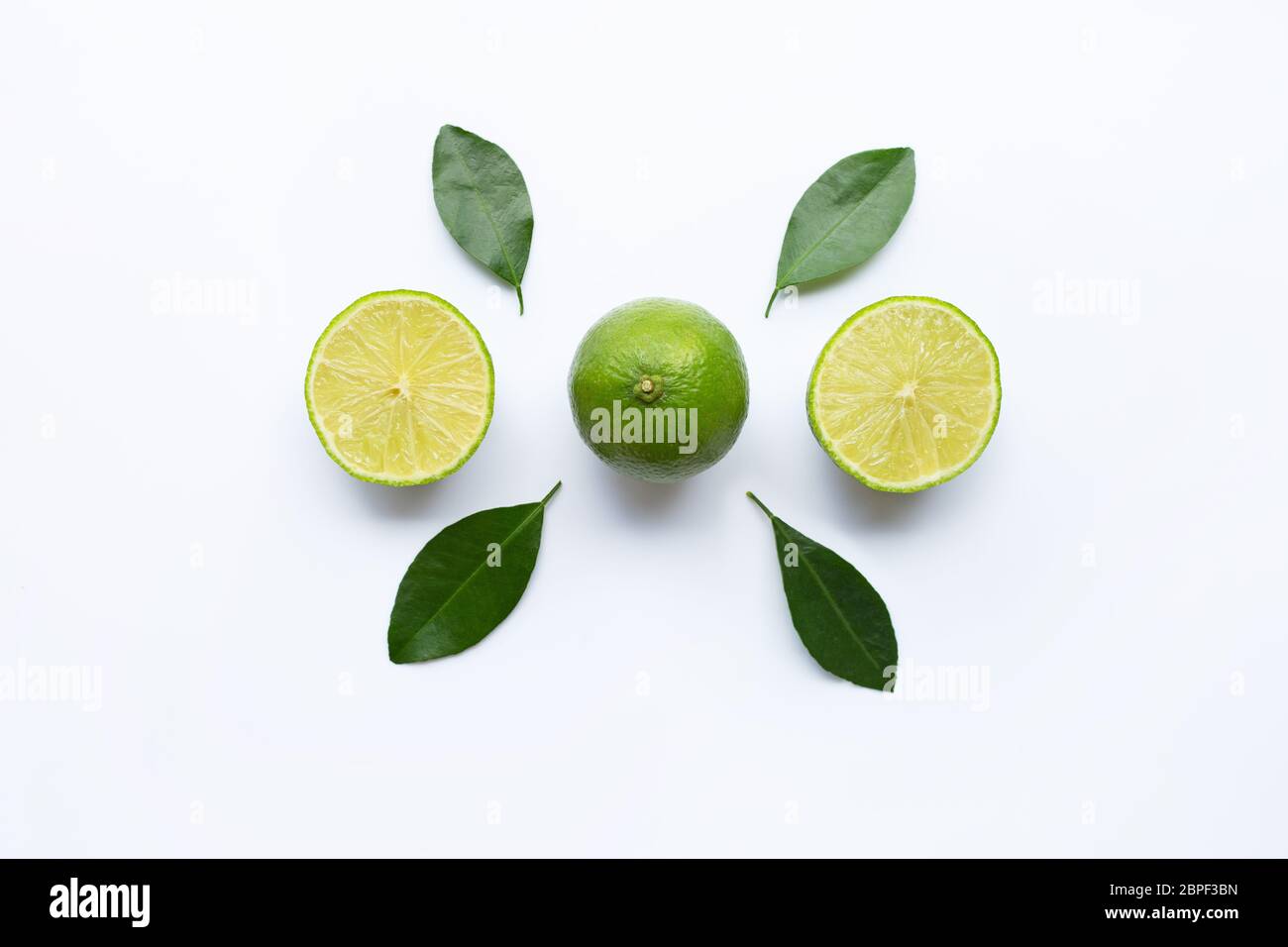 Ripe limes with green leaves on white background Stock Photo - Alamy