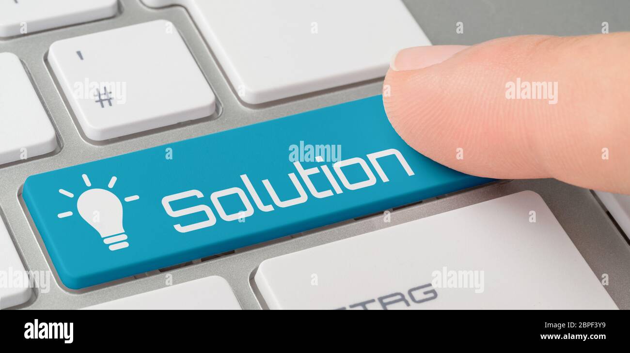 A keyboard with a blue labeled button - Solution Stock Photo - Alamy