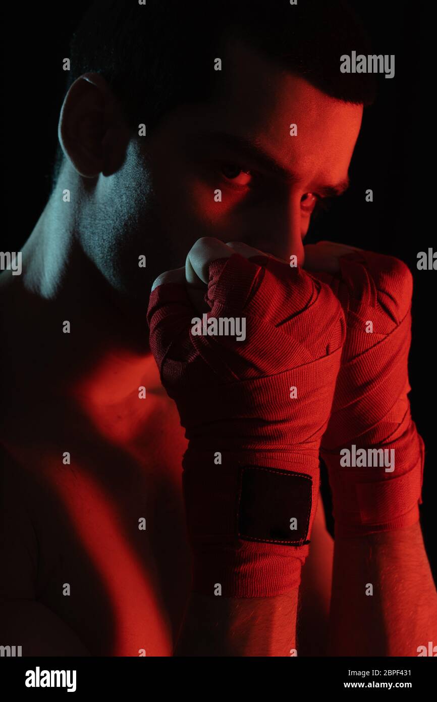 Fighter close up portrait before fight, over black background in red ...