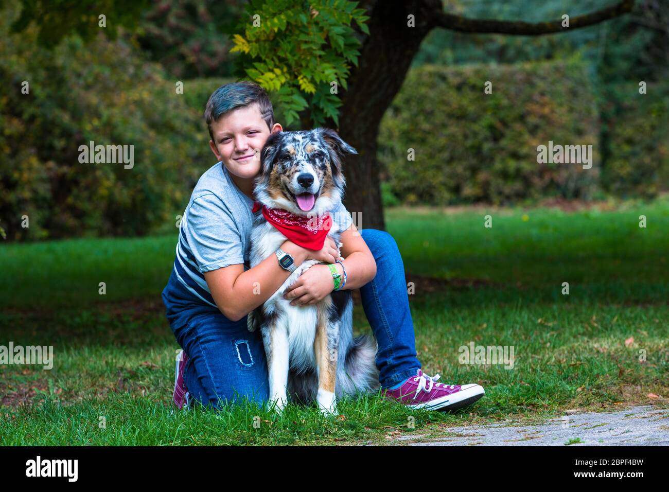 young boy gives dog a hug and is happy Stock Photo - Alamy