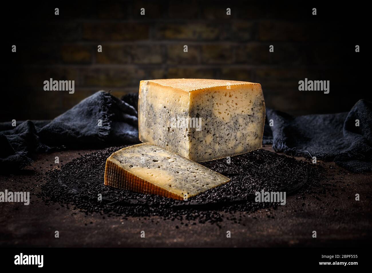 Slice segment of a cheese wheel on dark vintage background Stock Photo ...
