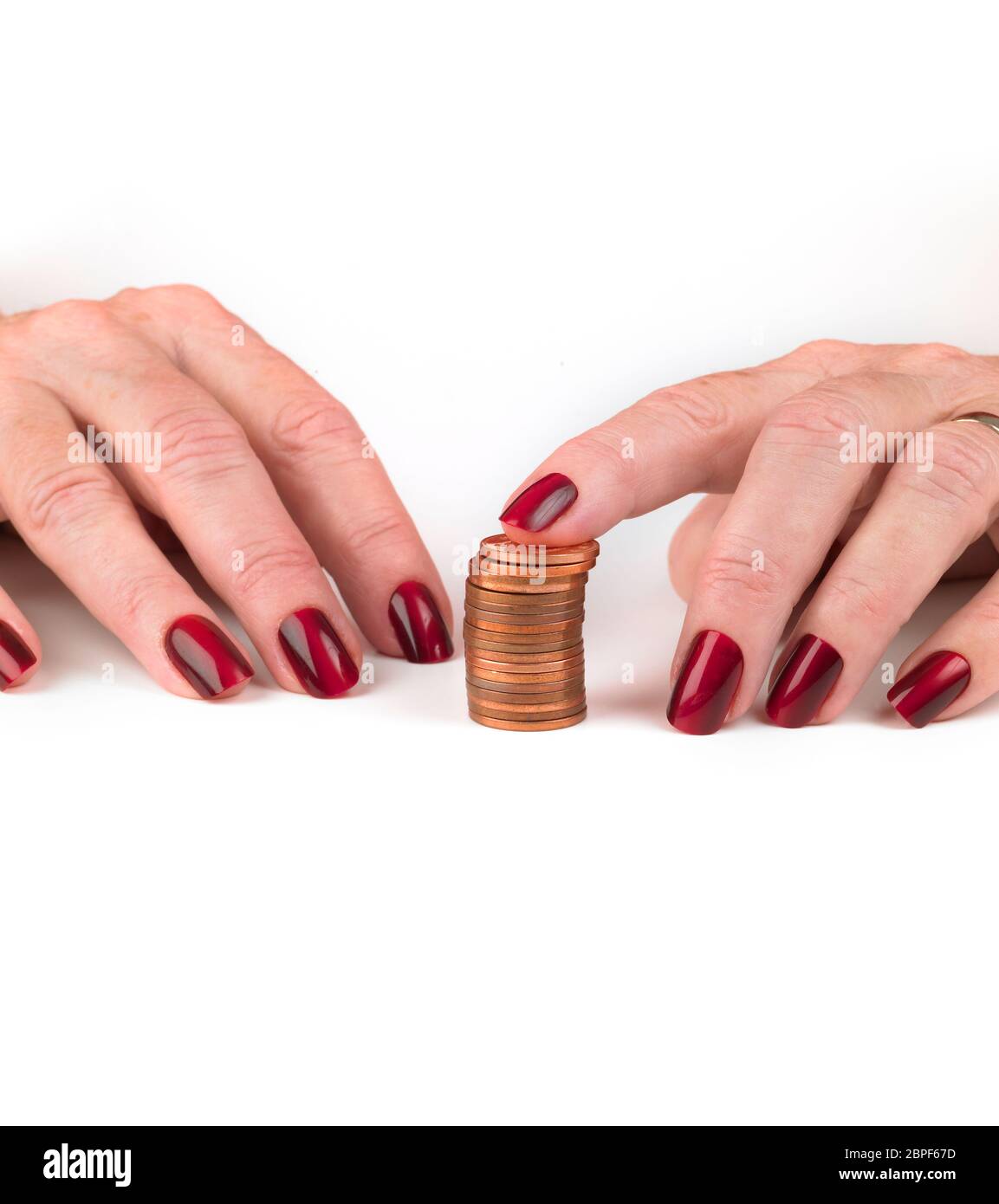 Middle age womans hands with bright red nails counting pile of coins on ...