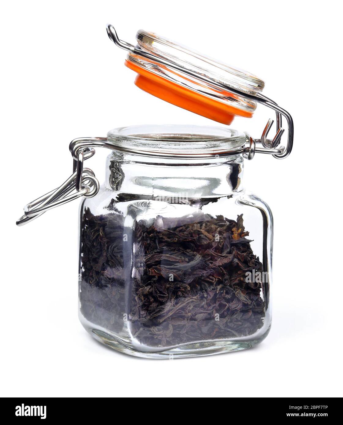 Large leaf black tea in a transparent glass jar with an open lid ...