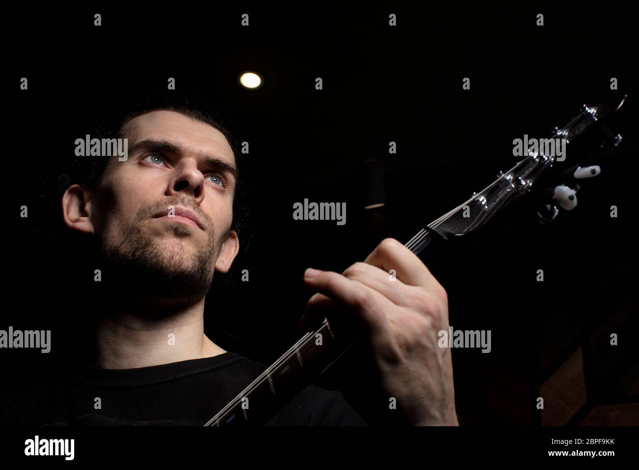 A man plays the guitar. Face of a man with a musical instrument on a ...