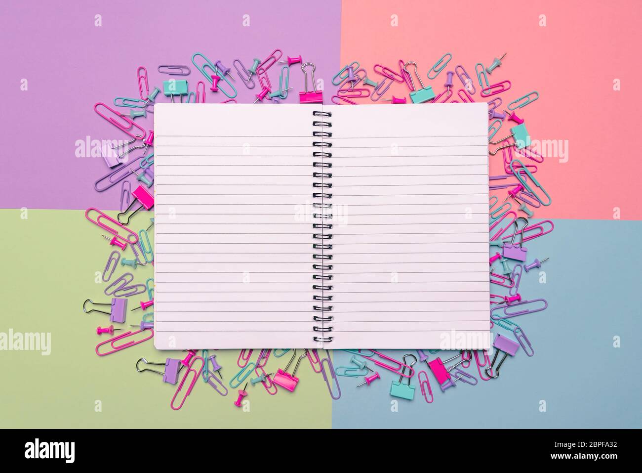 Blank open notebook and multitude of office supplies, paper clamps ...