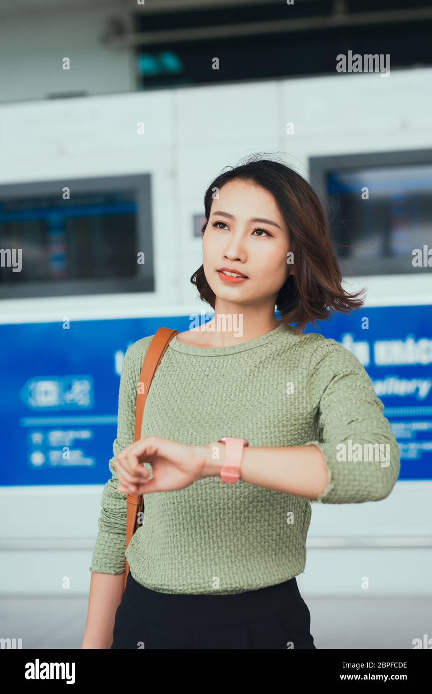 Elegant woman setting her watch standing in airport Stock Photo - Alamy