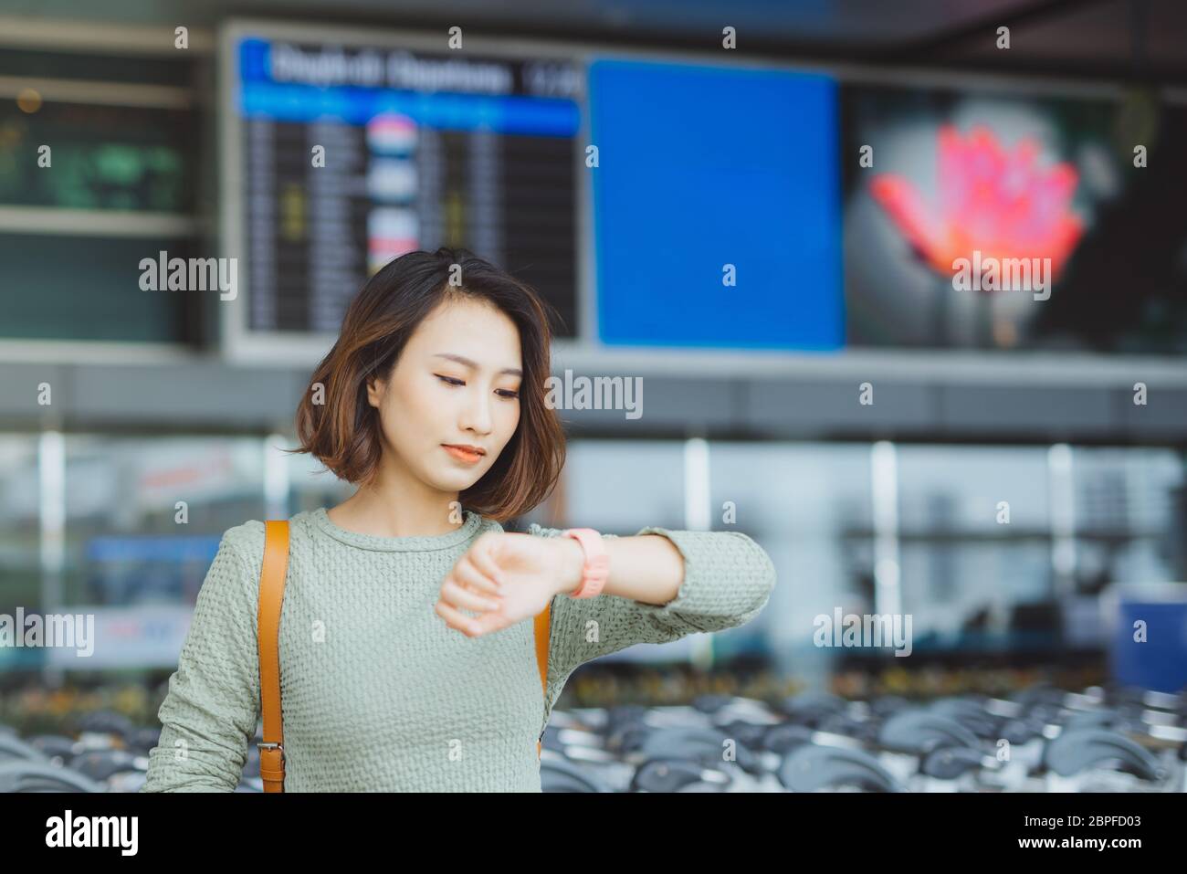 Elegant woman setting her watch standing in airport Stock Photo - Alamy