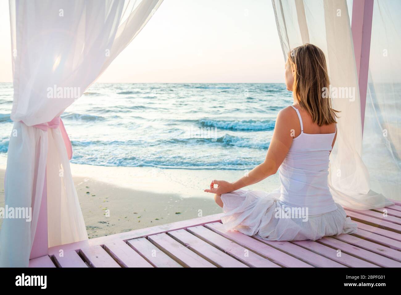 Woman meditating at the sea Stock Photo - Alamy