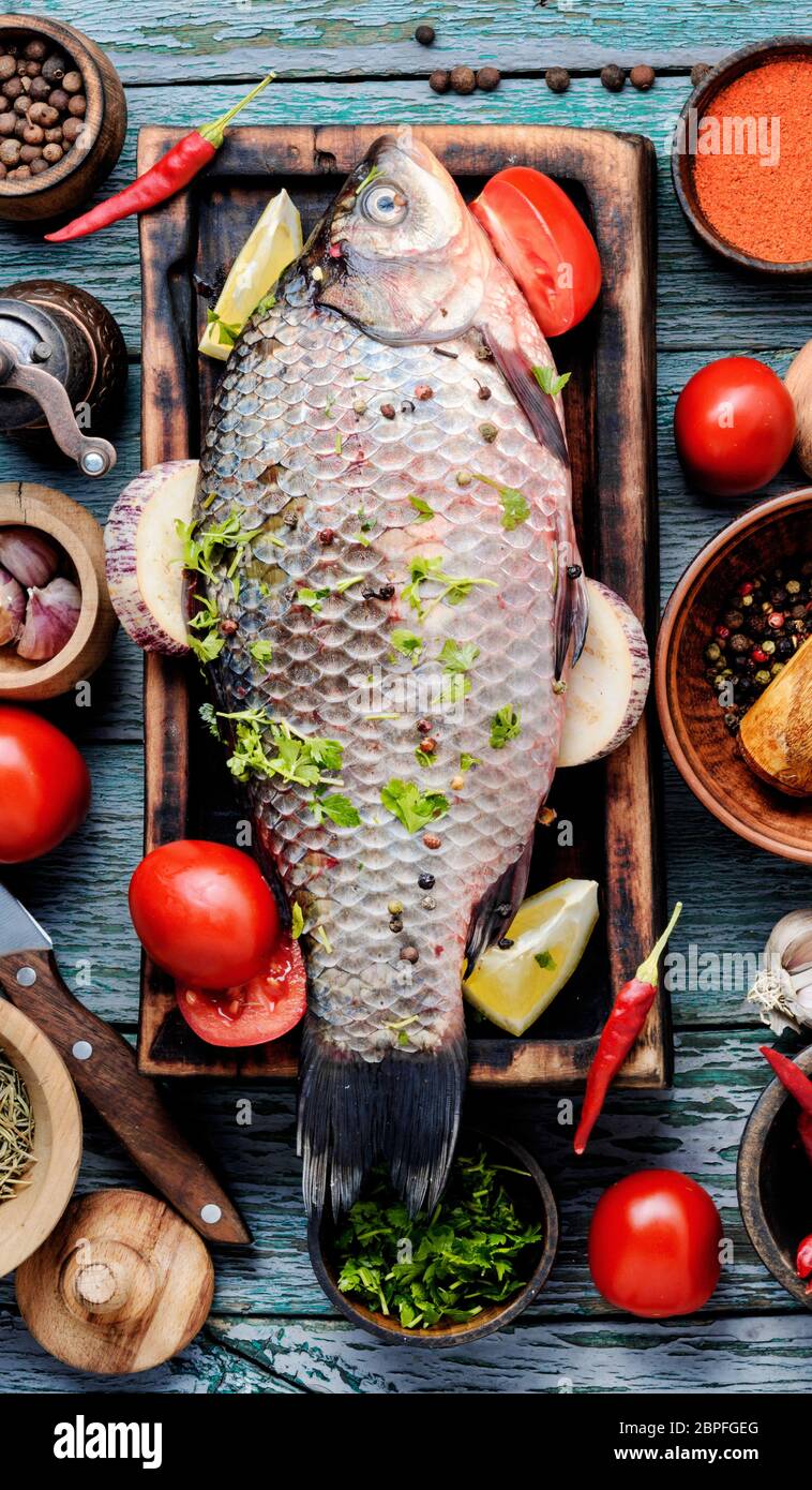 Fresh fish with ingredients on rustic cutting board.Cooking concept ...