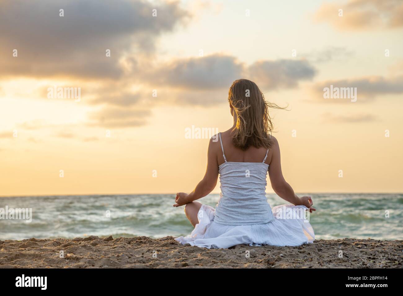 Woman meditating at the sea Stock Photo - Alamy