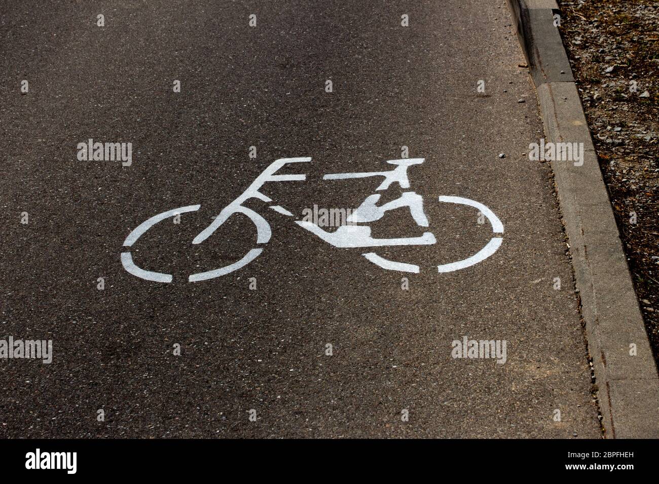 Bicycle lane symbol painted on a road next to a curb Stock Photo - Alamy