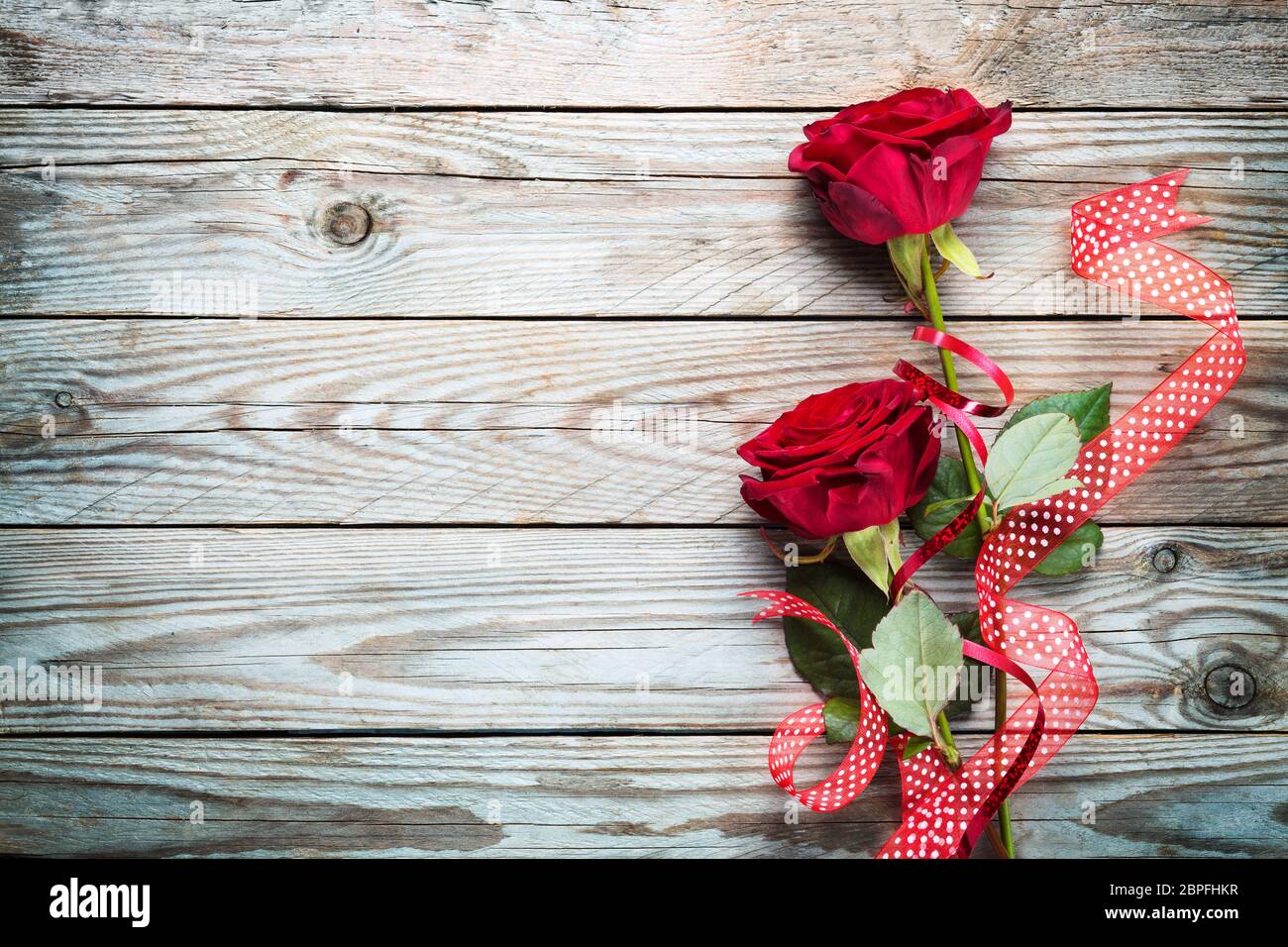 Bouquet of red roses on wooden rustic background Stock Photo - Alamy