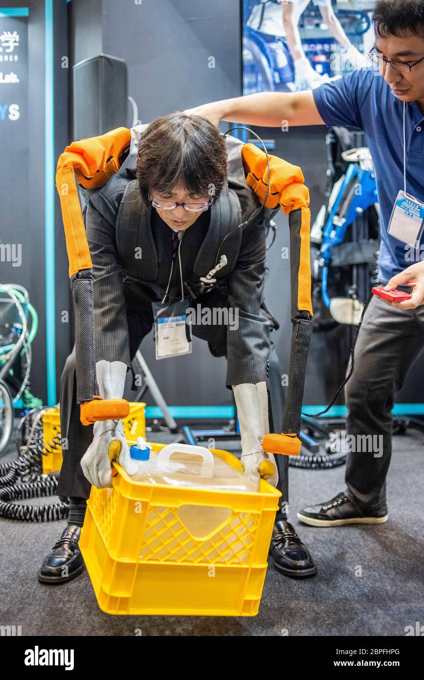 A visitor tries an exoskeleton robot suit during the Japan Robot Week exhibition in Tokyo, Japan ...