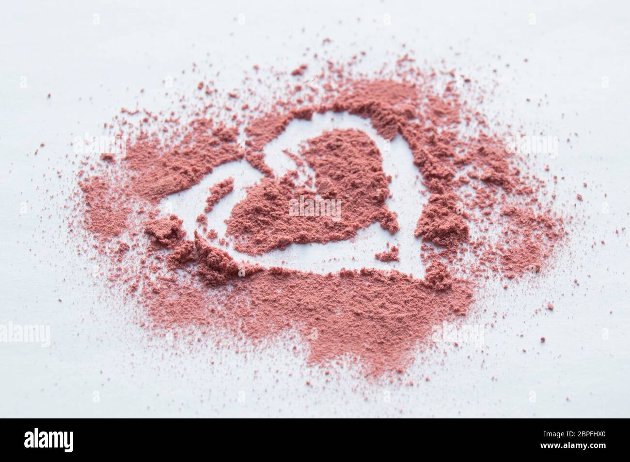 The texture of the ground powder in the form of heart isolated on white ...