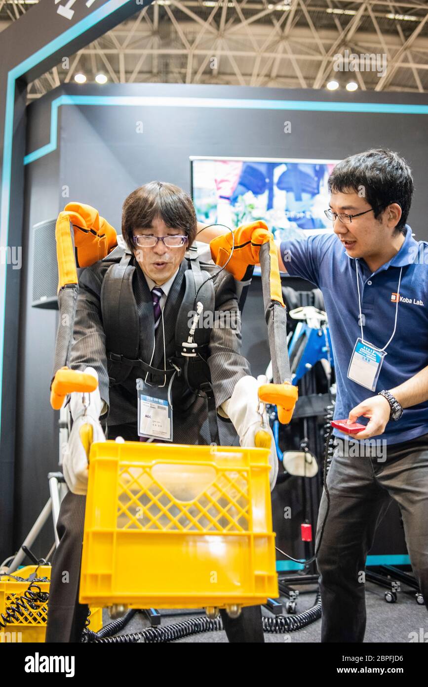 A visitor tries an exoskeleton robot suit during the Japan Robot Week ...