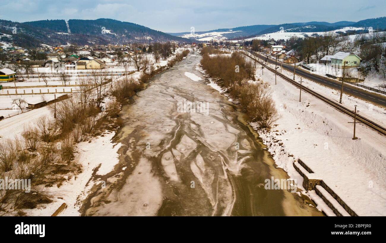 Frozen winter river. Aerial rural view of snowy village, road and ...