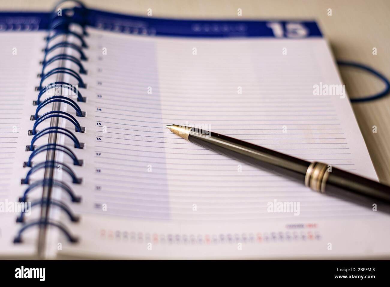 a black pen on an open spiral notebook. Business and scheduling concept ...