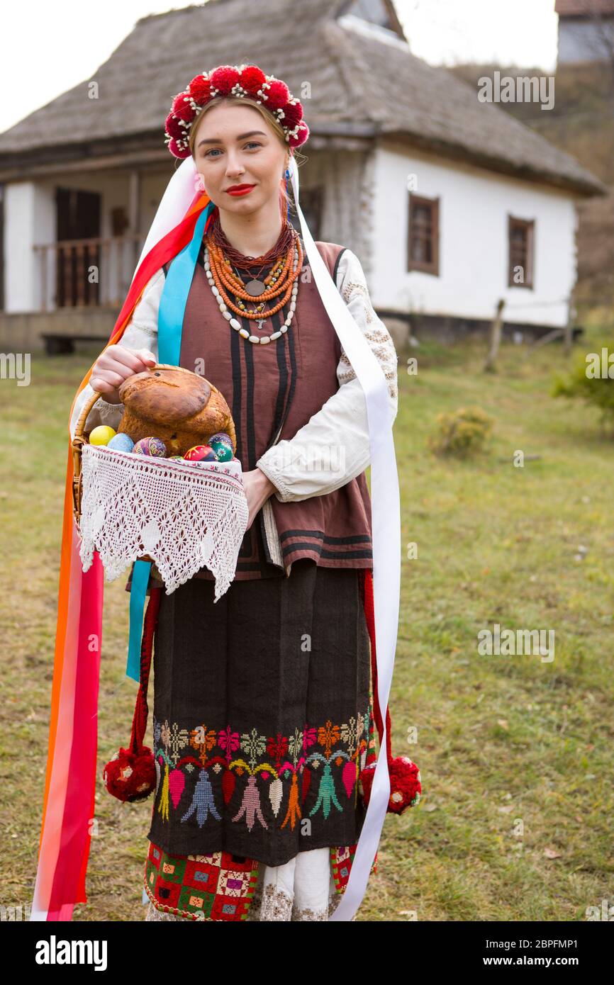 Beautiful girl in national dress with Easter and eggs in a basket ...