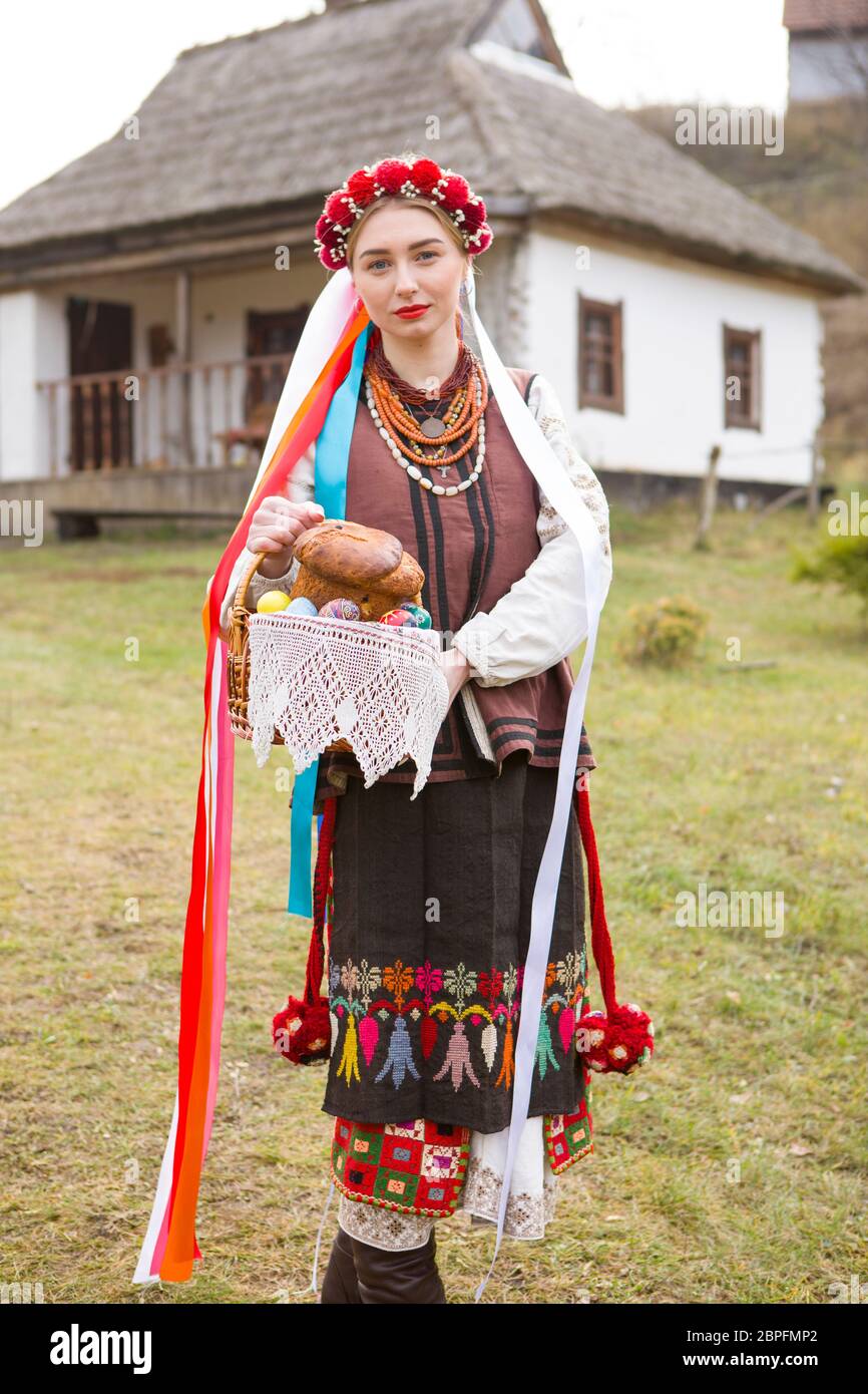 Beautiful girl in national dress with Easter and eggs in a basket ...