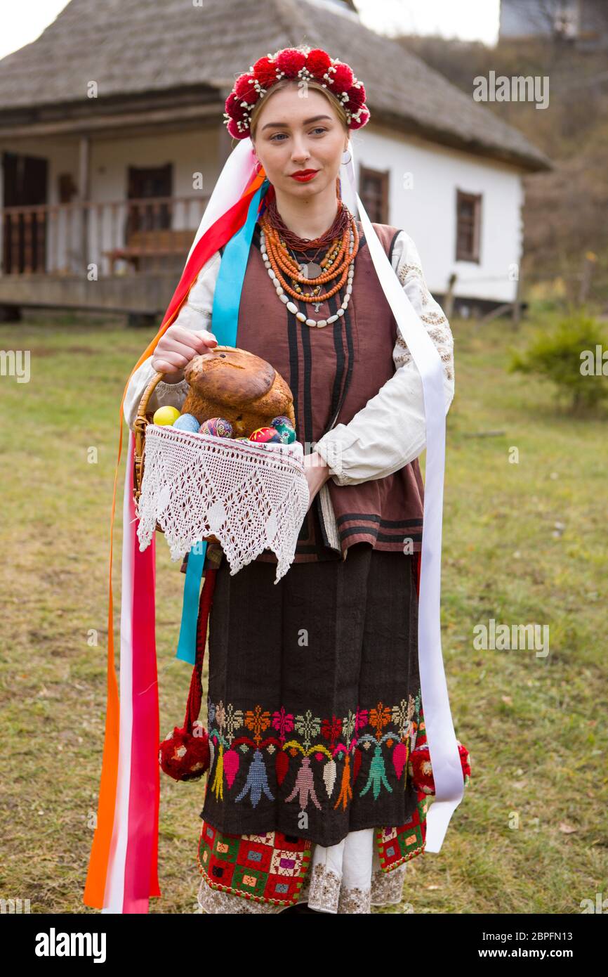 Beautiful girl in national dress with Easter and eggs in a basket ...