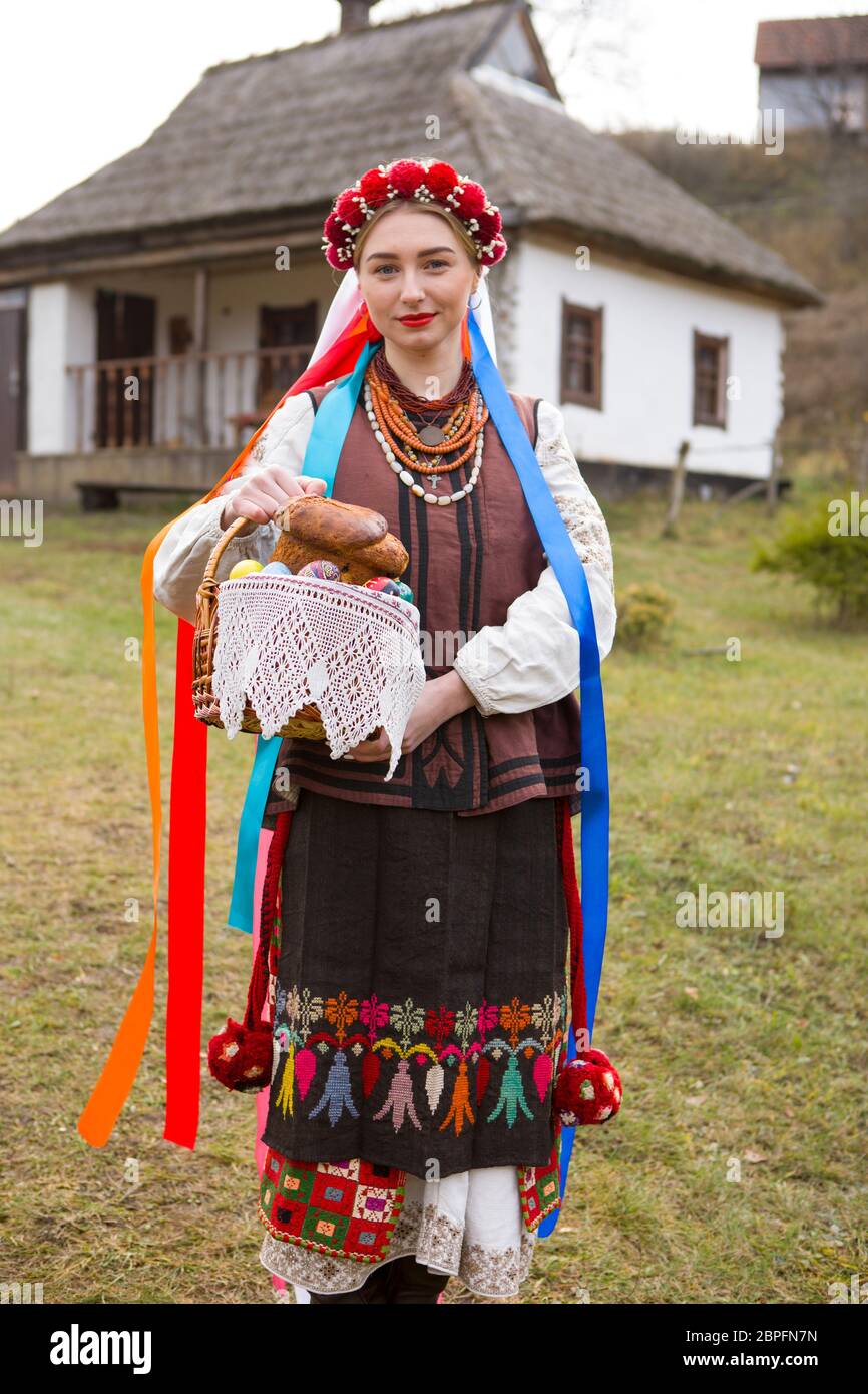 Beautiful girl in national dress with Easter and eggs in a basket ...