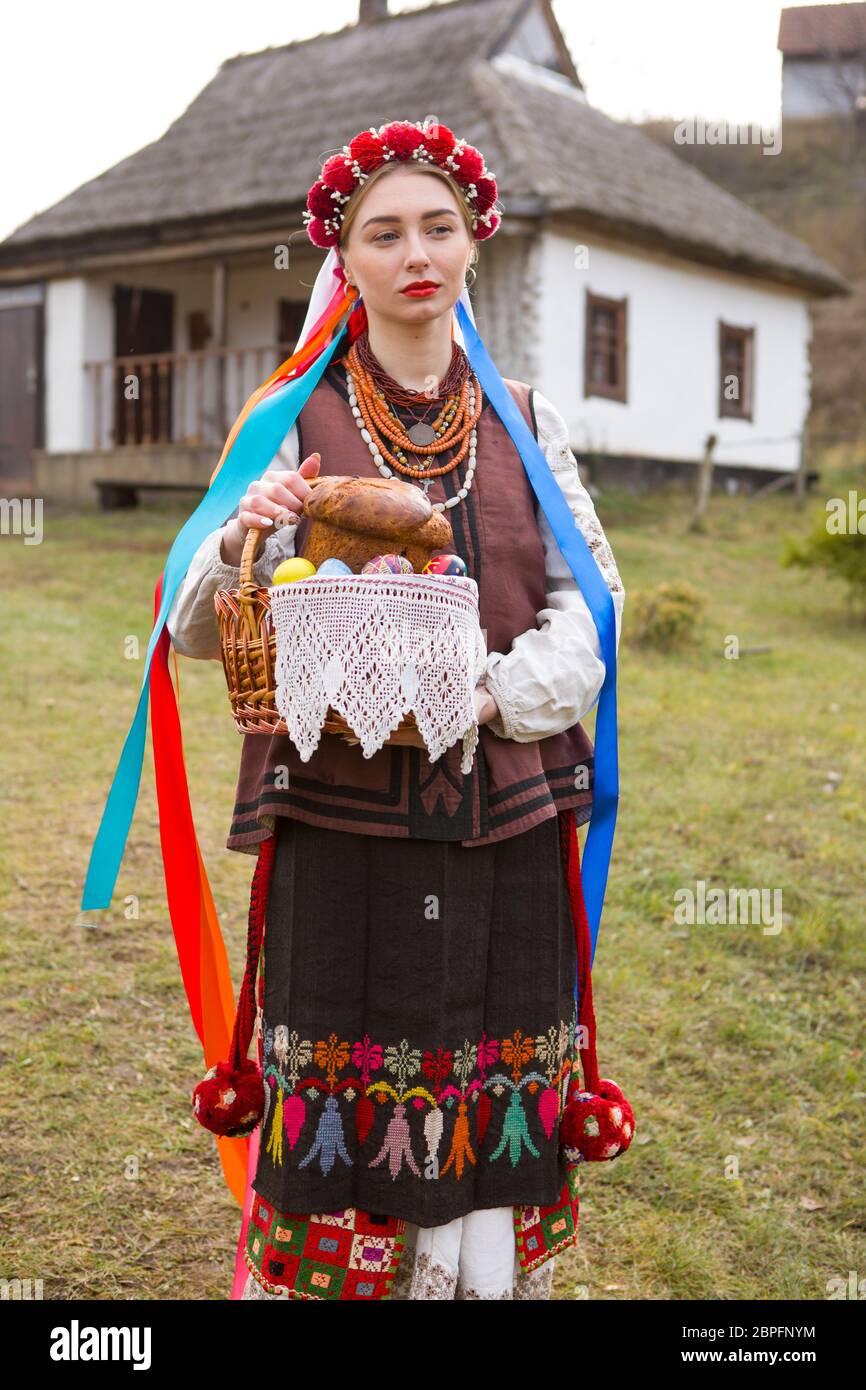 Beautiful girl in national dress with Easter and eggs in a basket ...