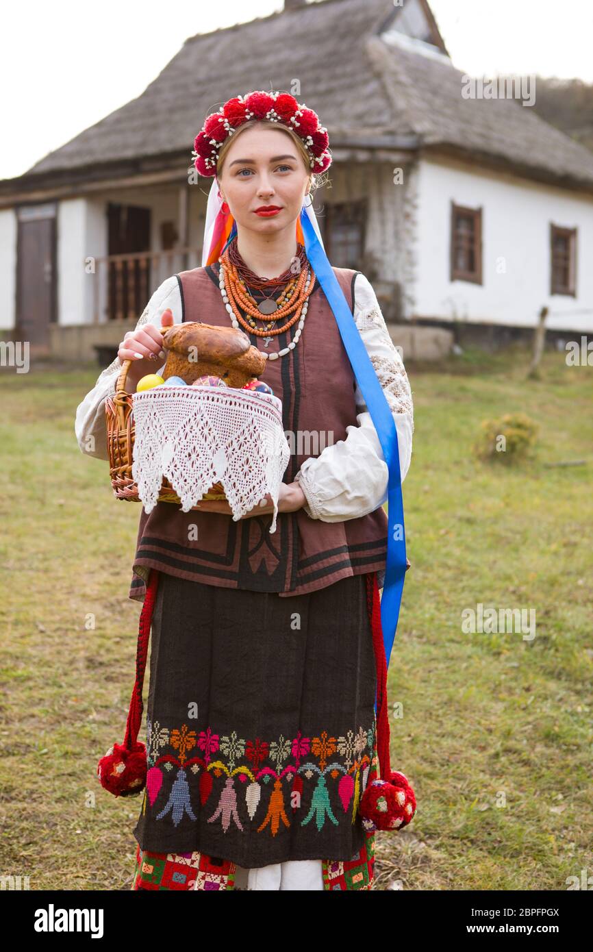 Beautiful girl in national dress with Easter and eggs in a basket ...
