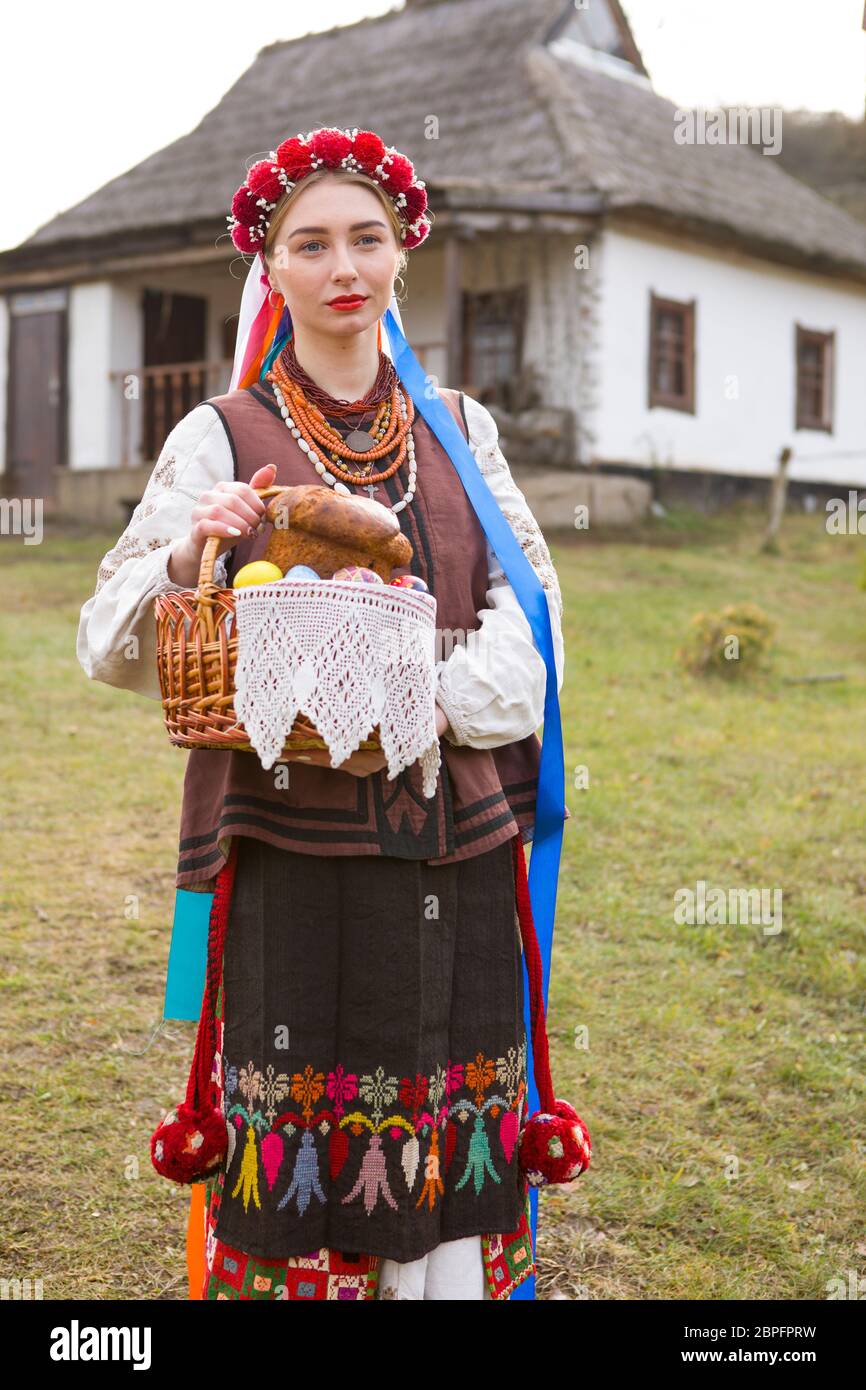 Beautiful girl in national dress with Easter and eggs in a basket ...