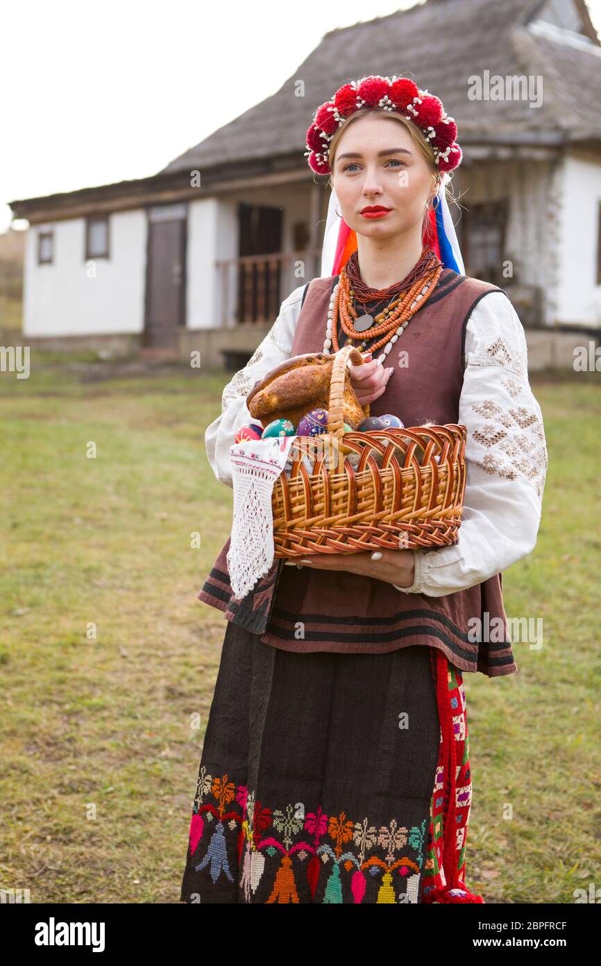 Beautiful girl in national dress with Easter and eggs in a basket ...