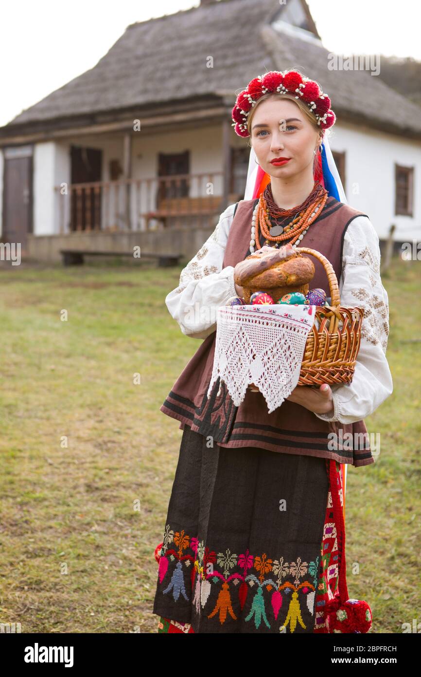 Beautiful girl in national dress with Easter and eggs in a basket ...