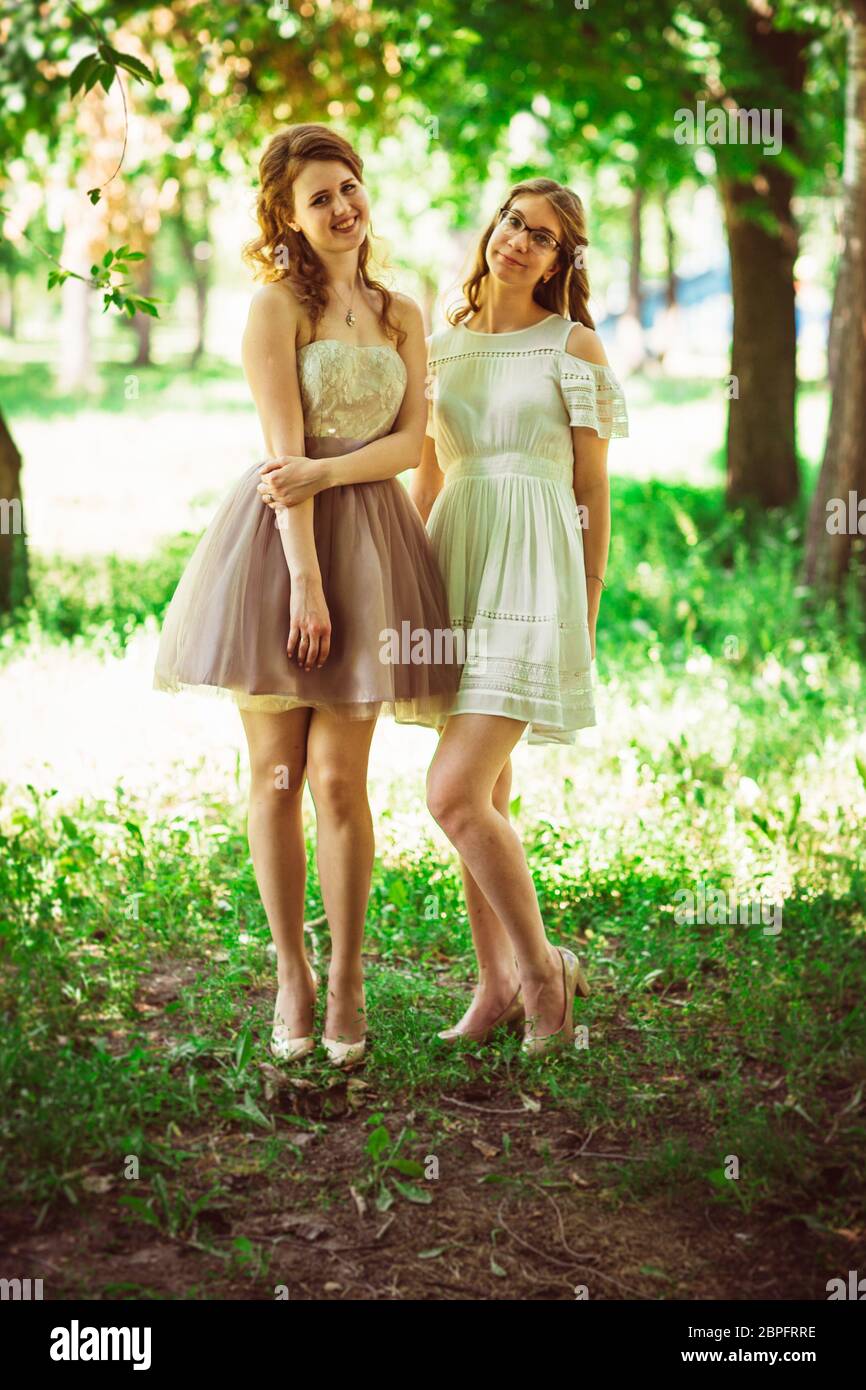 Two beautiful girlfriends on a plant background Stock Photo - Alamy