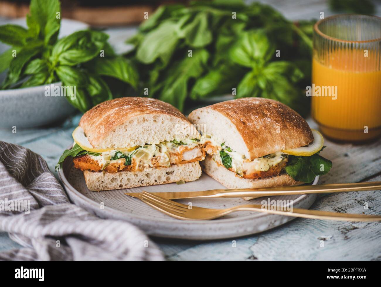 Breakfast with fish sandwich, fresh greens and orange juice Stock Photo ...