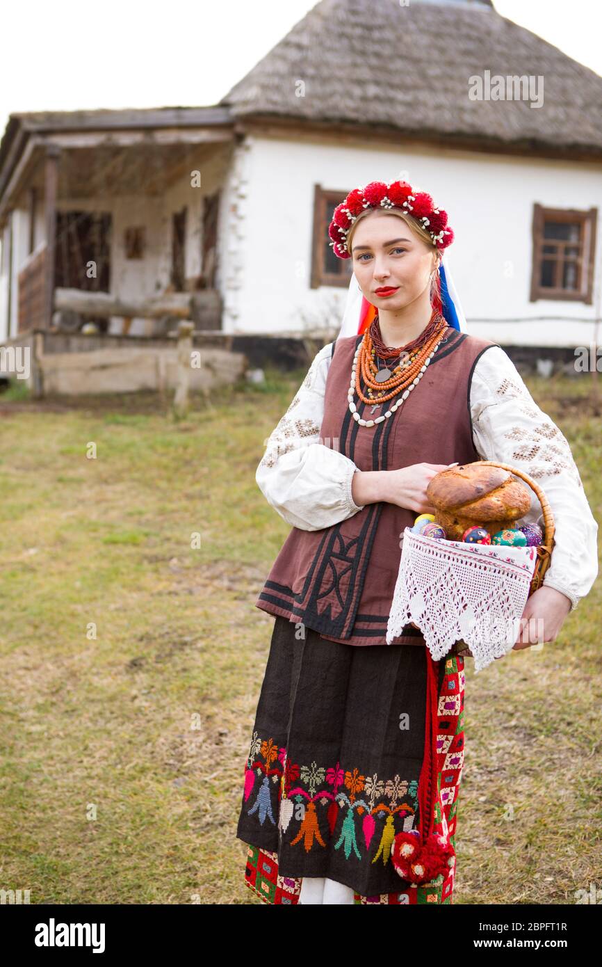Beautiful girl in national dress with Easter and eggs in a basket ...