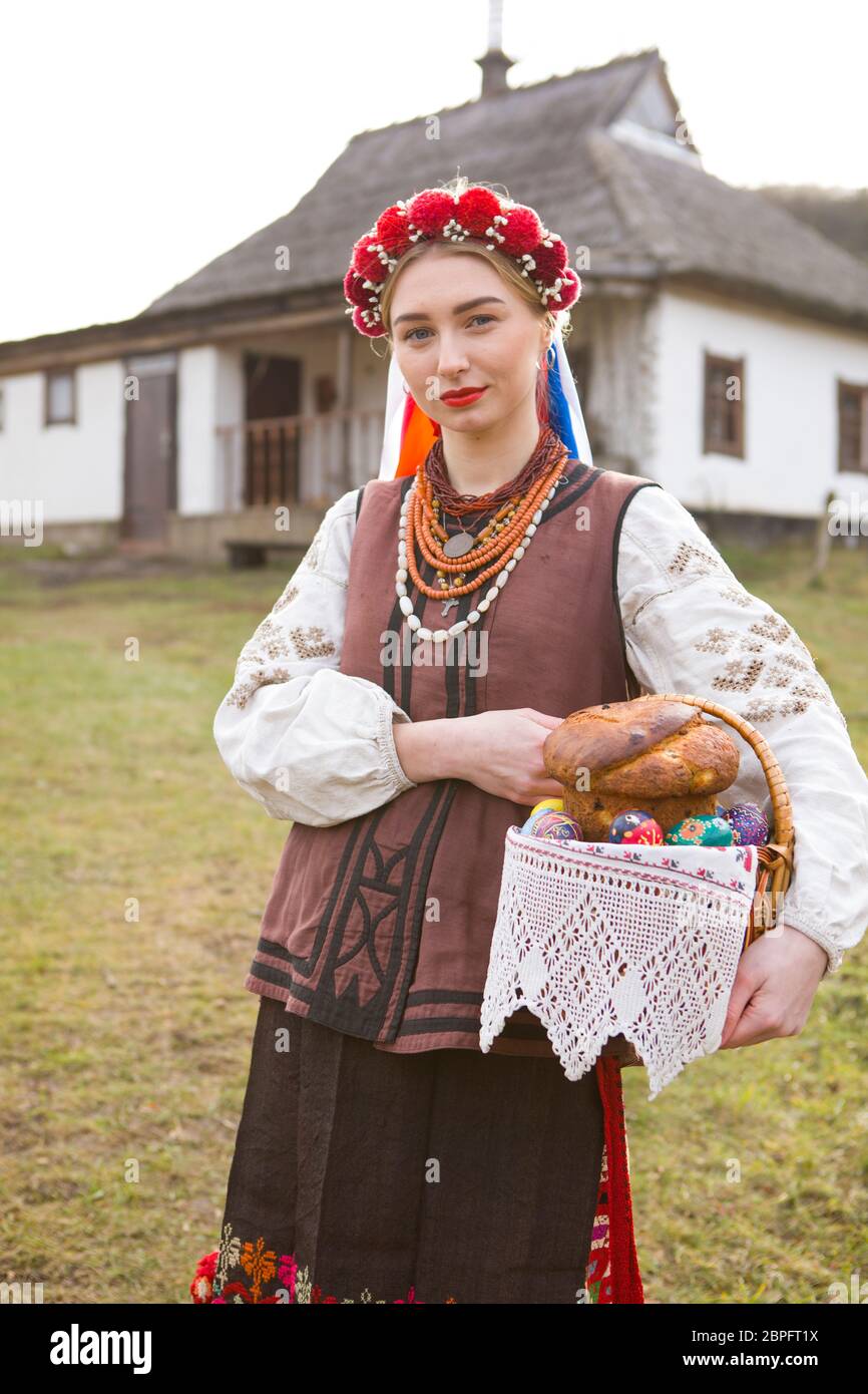 Beautiful girl in national dress with Easter and eggs in a basket ...