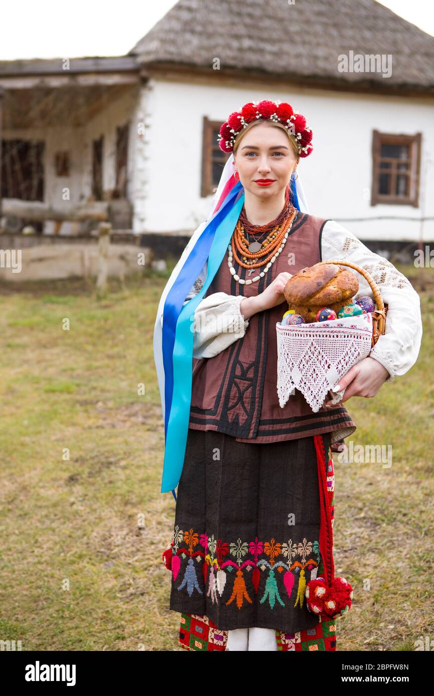 Beautiful girl in national dress with Easter and eggs in a basket ...