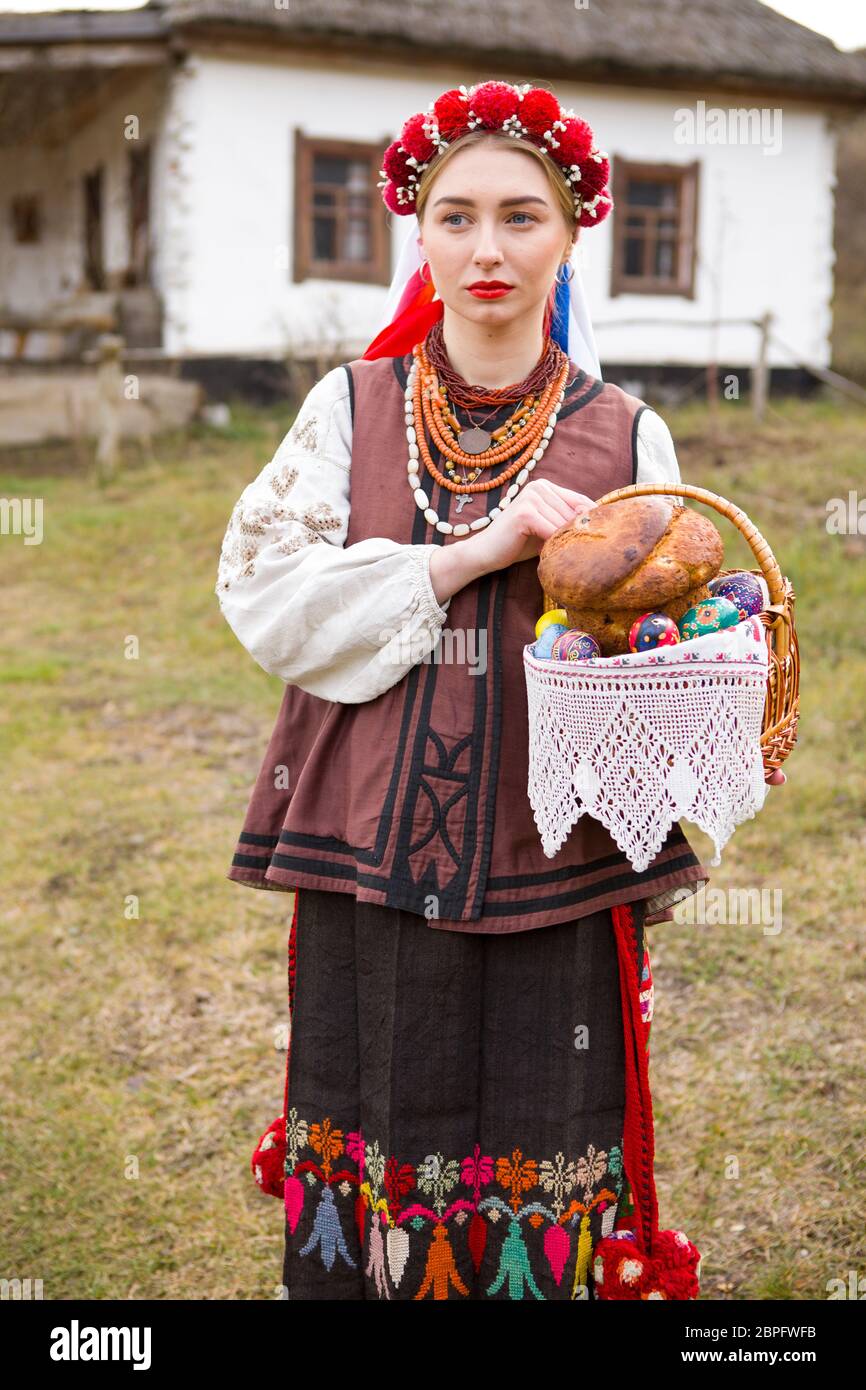 Beautiful girl in national dress with Easter and eggs in a basket ...
