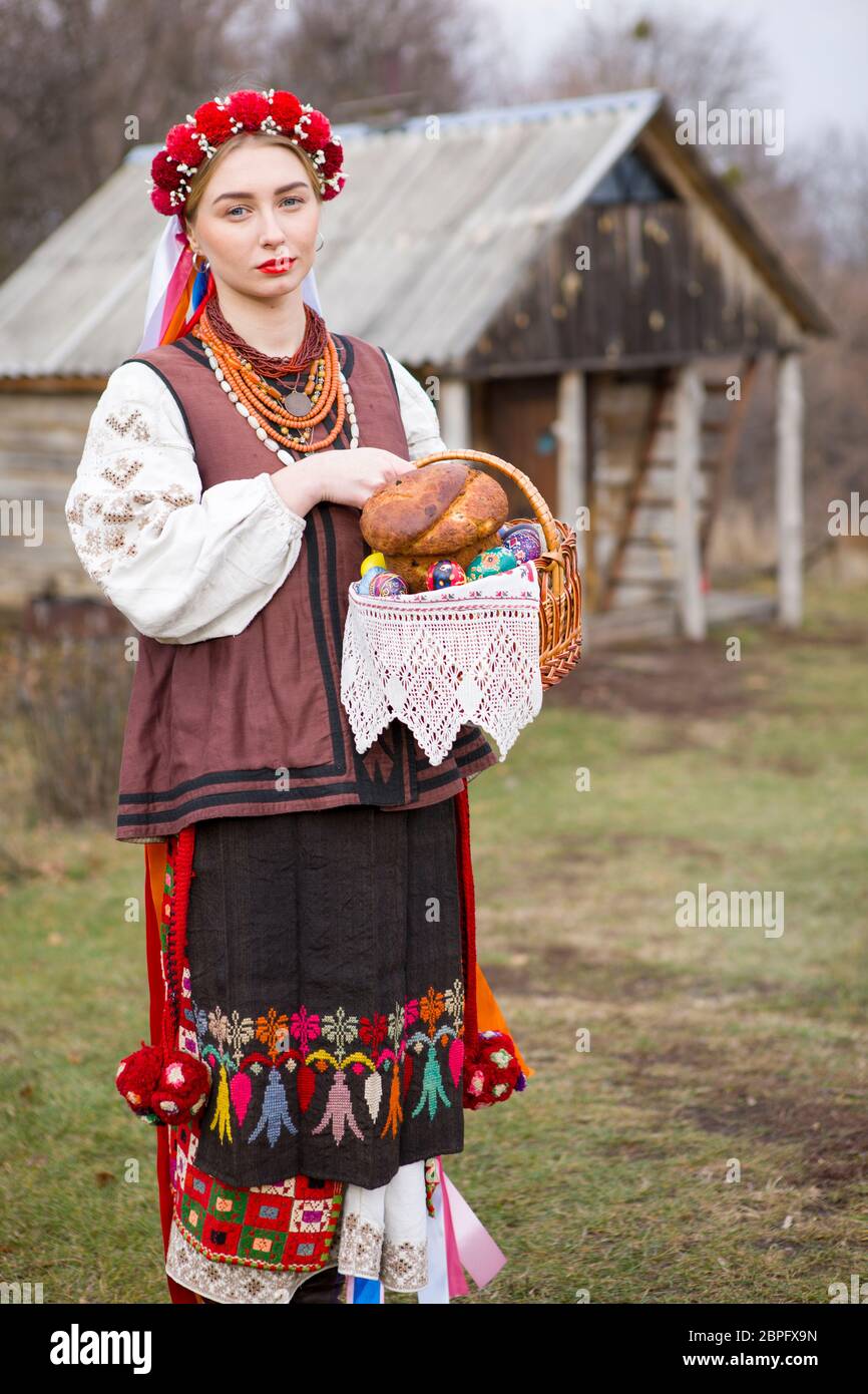 Beautiful girl in national dress with Easter and eggs in a basket ...