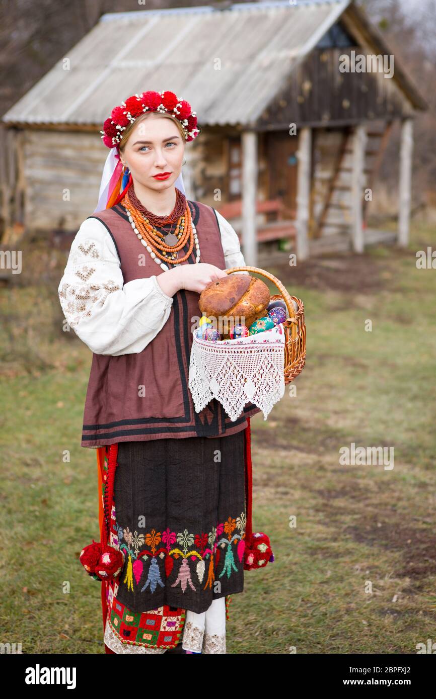Beautiful girl in national dress with Easter and eggs in a basket ...