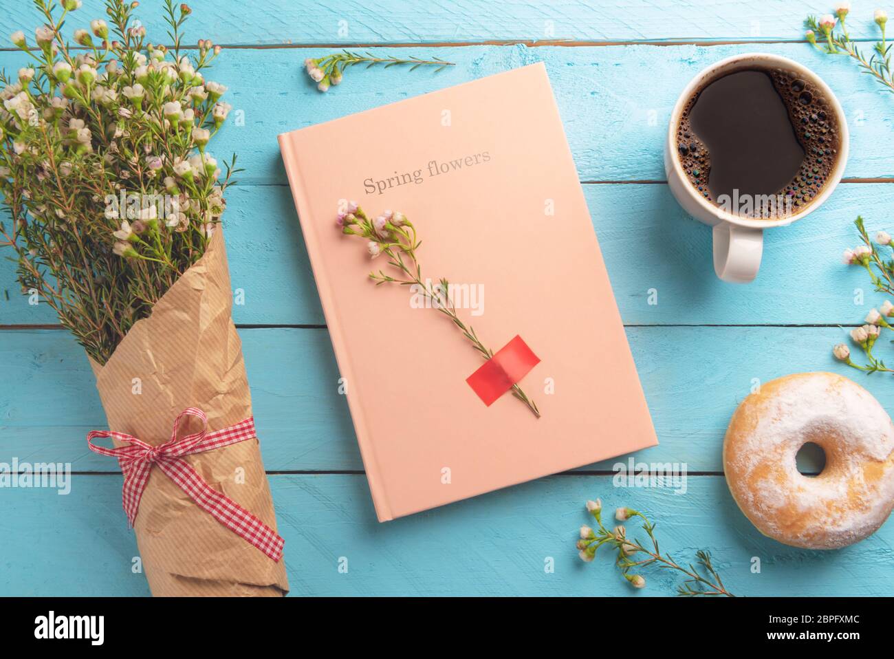 Breakfast on a blue table with hot coffee and donut. Pink notebook and ...