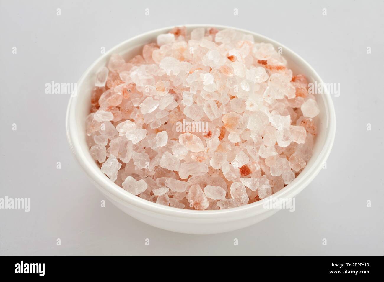 Bowl of coarse pink Himalaya salt, a rock salt or halite used for ...